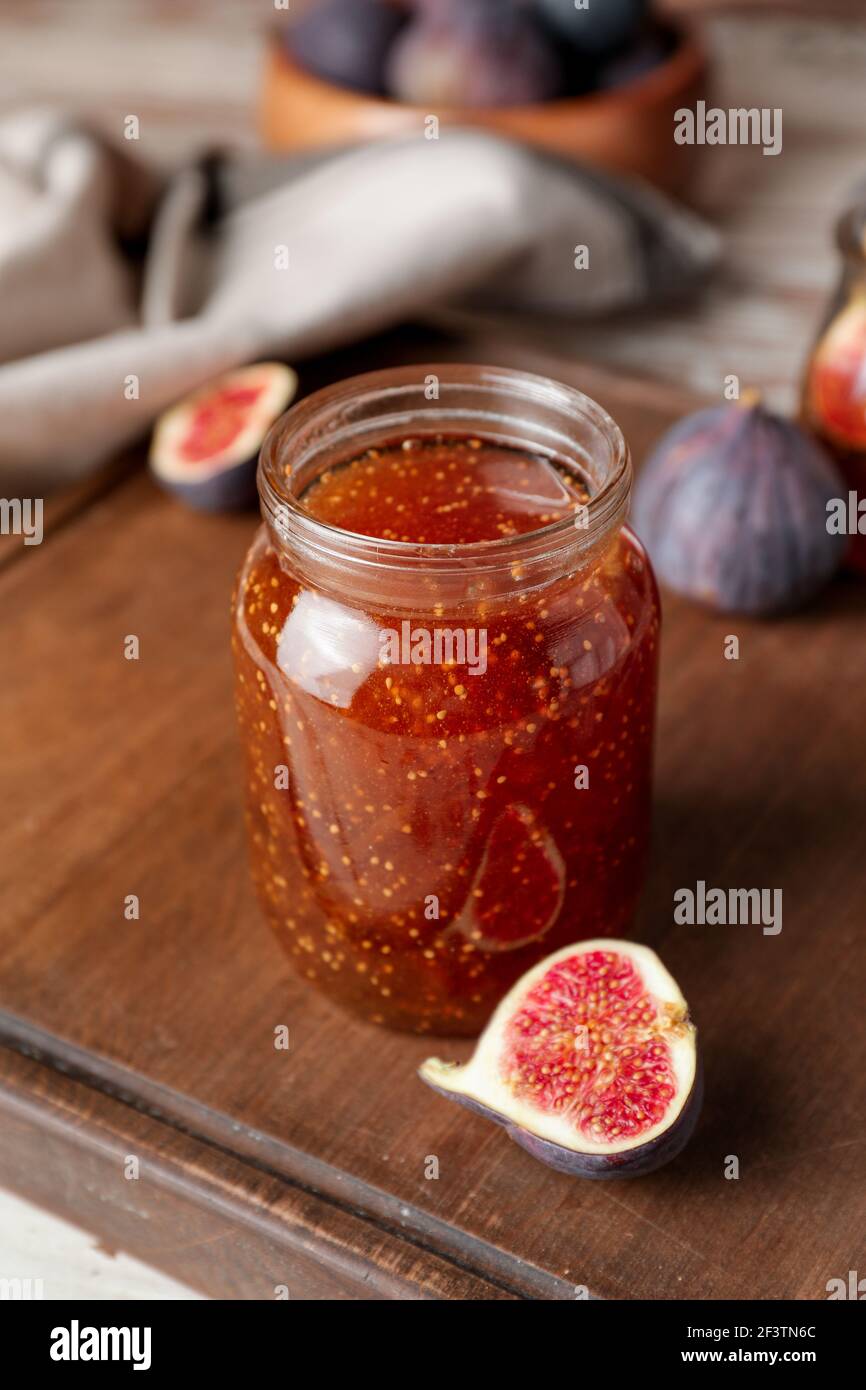 Jar of sweet fig jam on wooden table Stock Photo - Alamy