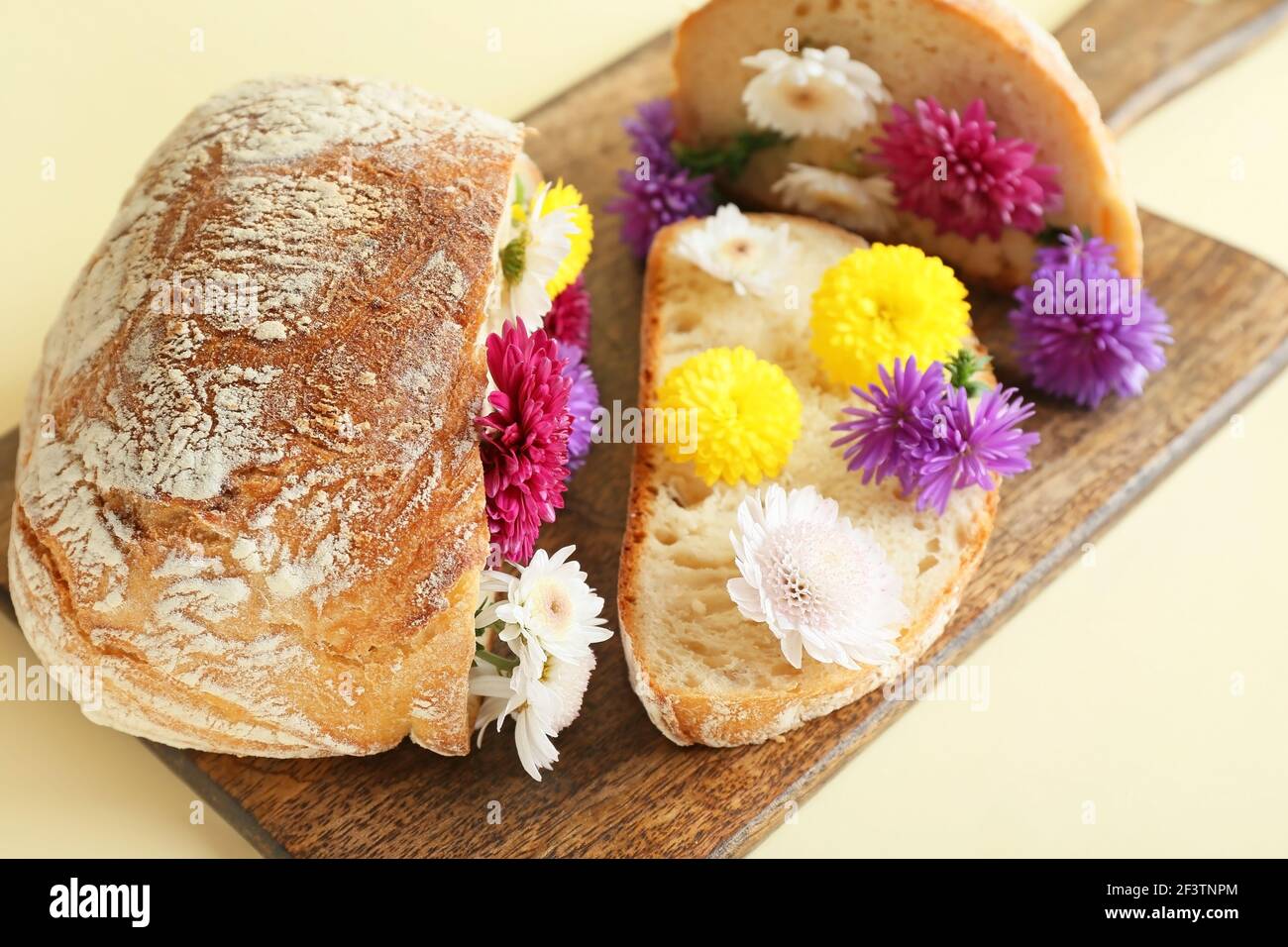 Fresh bread with flowers on color background, closeup Stock Photo - Alamy