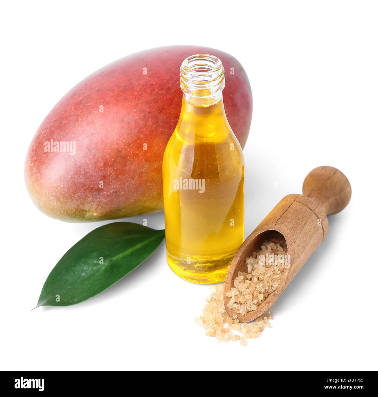 Bottle of essential oil, scoop with salt and fresh mango on white ...