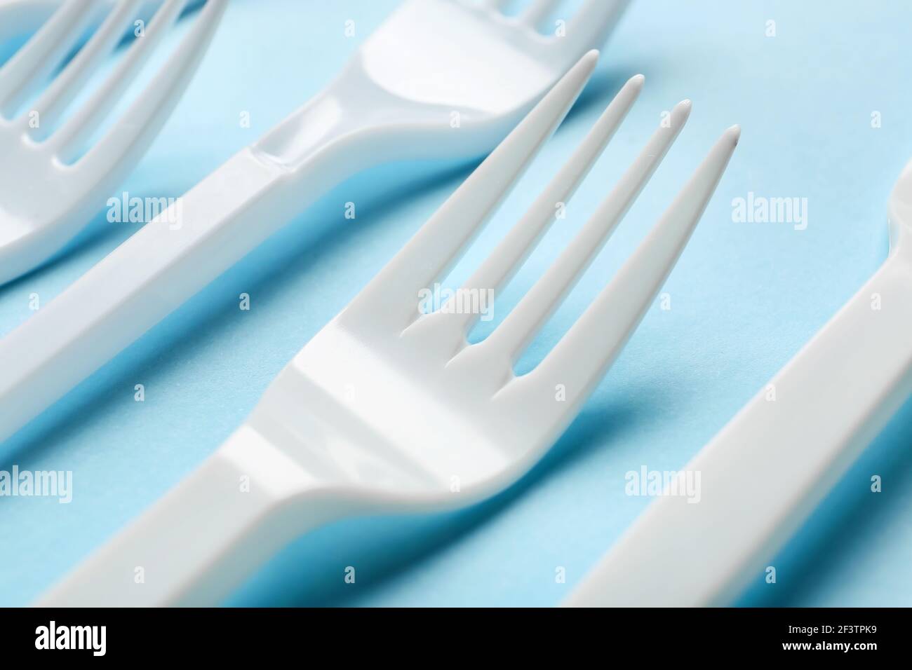Plastic forks on color background Stock Photo - Alamy