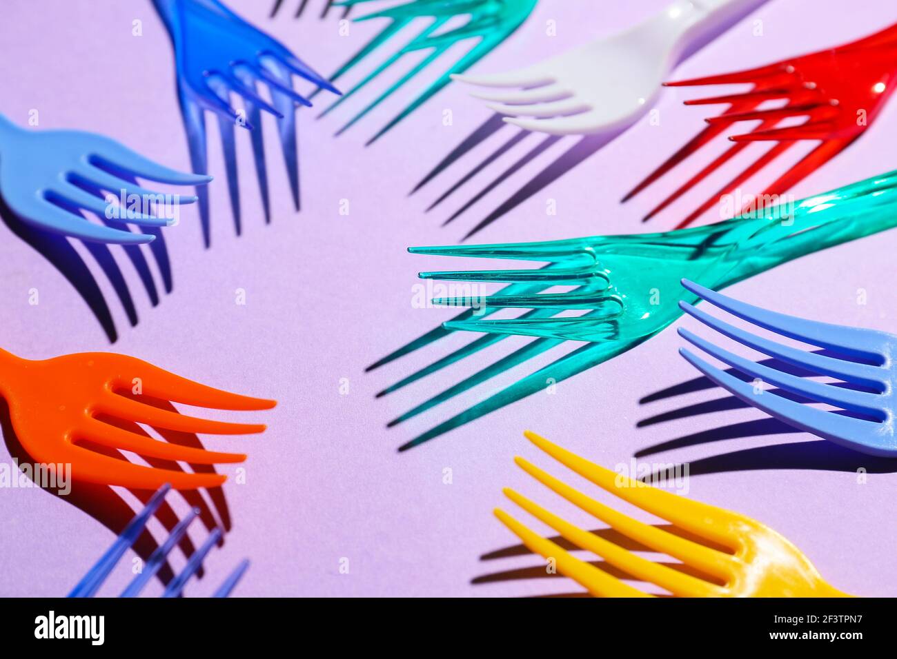 Plastic forks on color background Stock Photo - Alamy