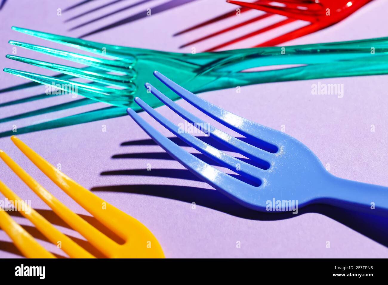 Plastic forks on color background Stock Photo - Alamy