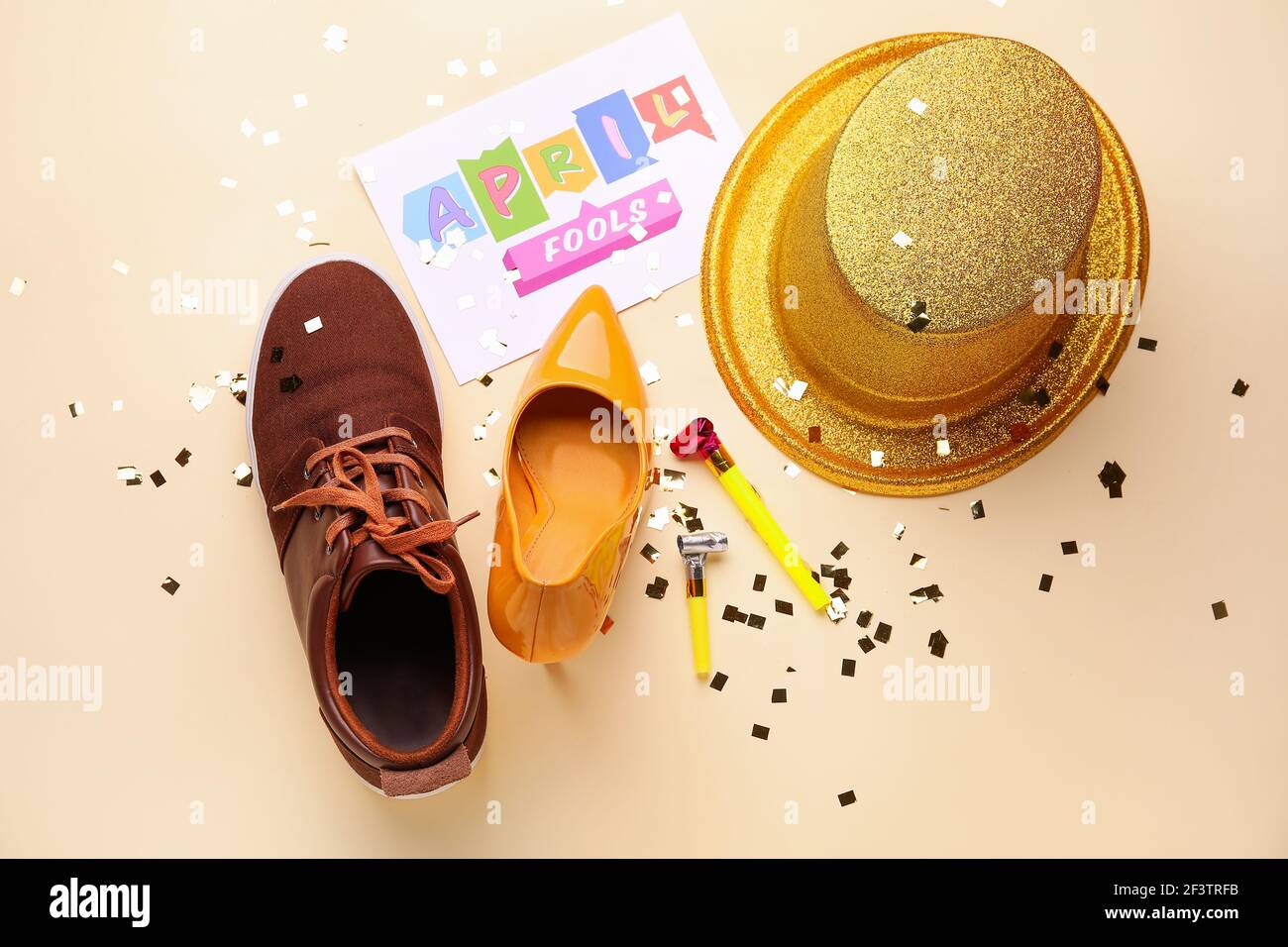 Different shoes with party decor on color background. April Fool's Day ...