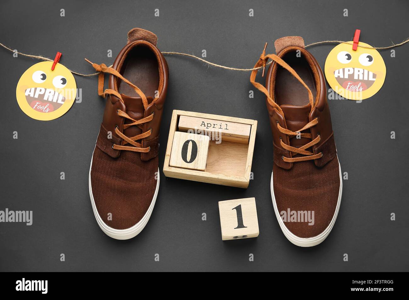 Shoes and calendar with date of April Fools Day on dark background ...