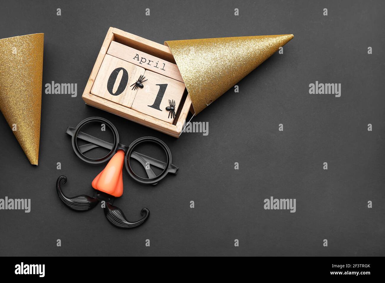 Party decor and calendar with date of April Fools Day on dark ...