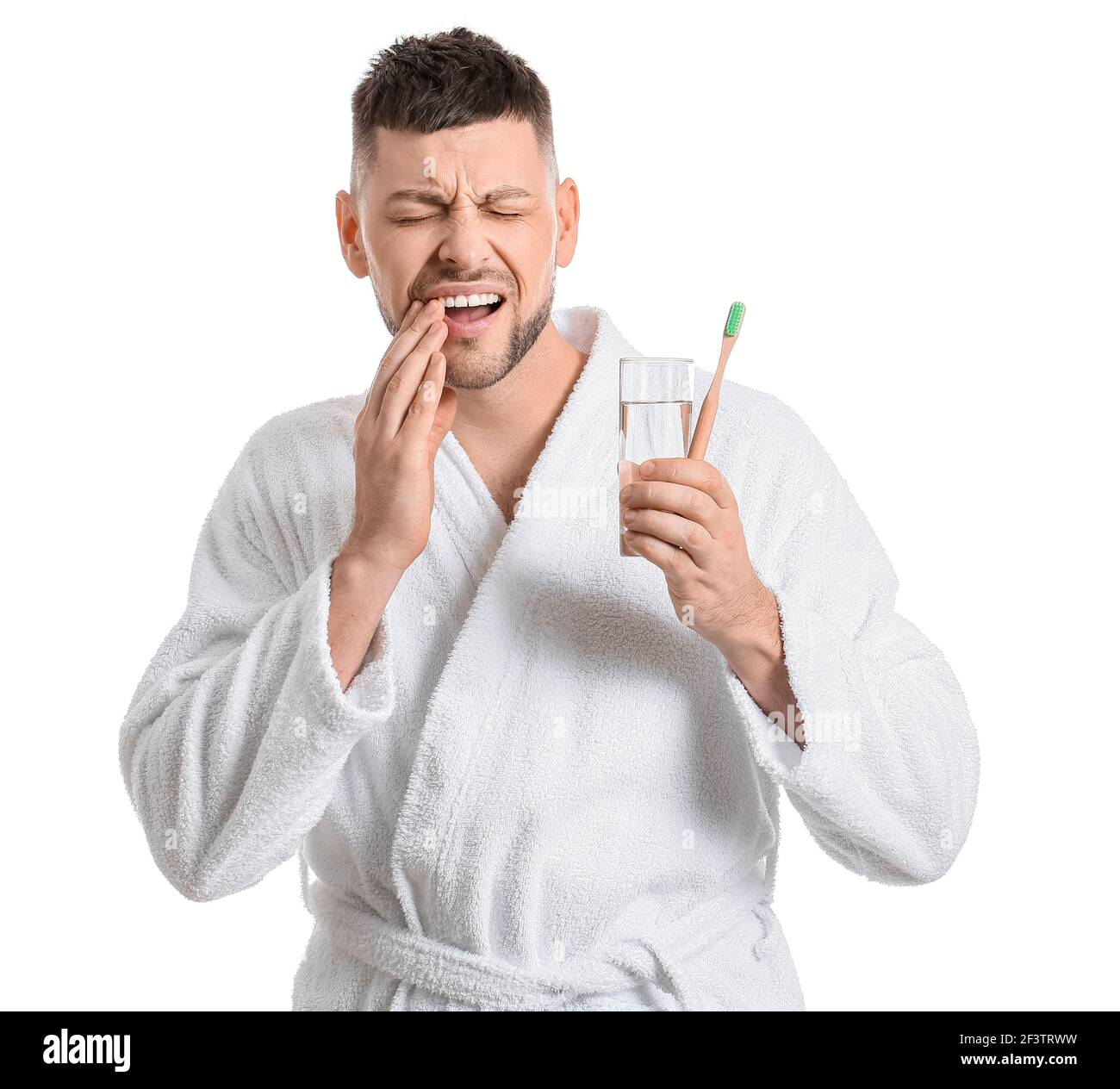 Man with aching teeth, glass of water and tooth brush on white ...