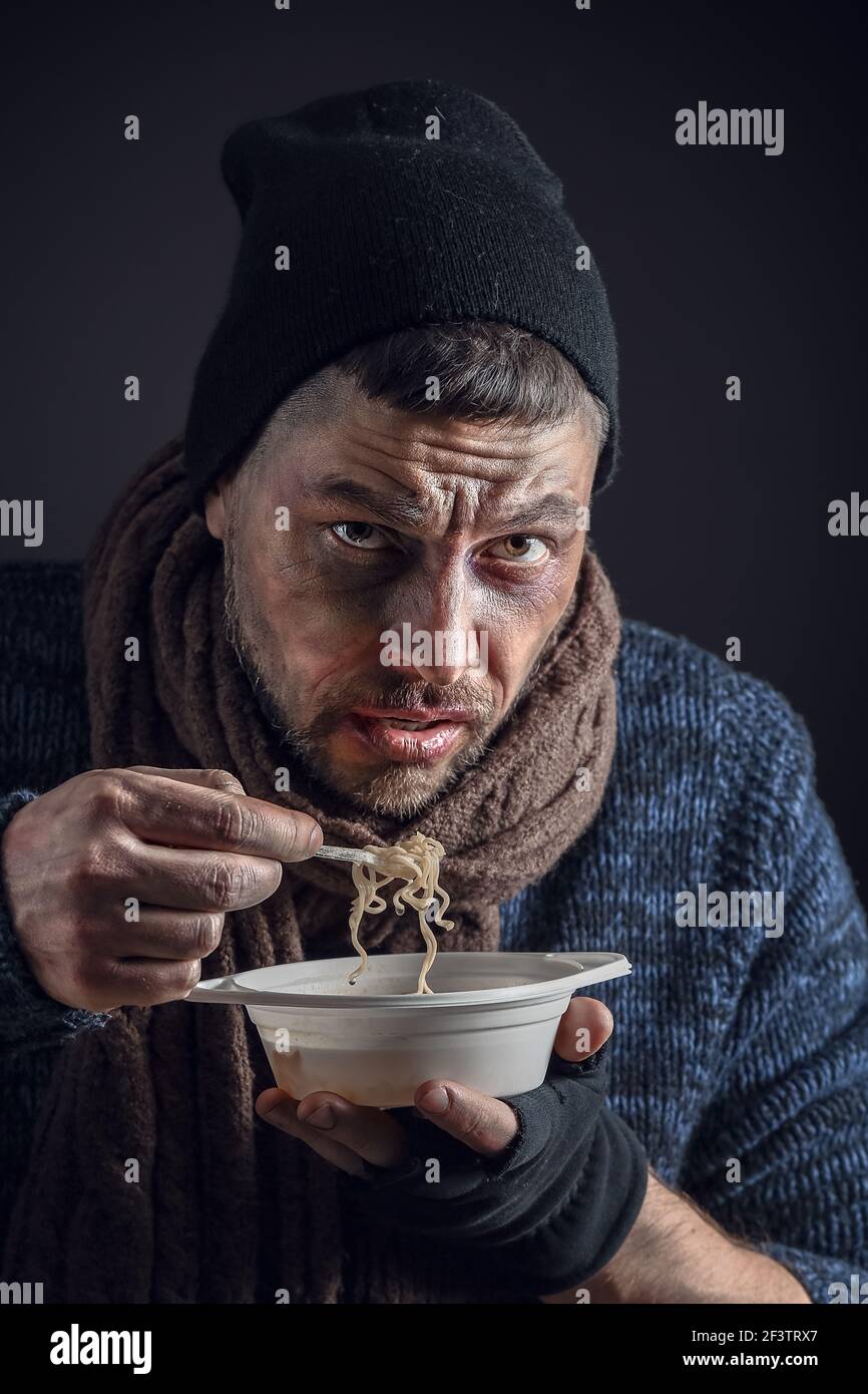 Portrait of poor homeless man with hot soup on dark background Stock ...