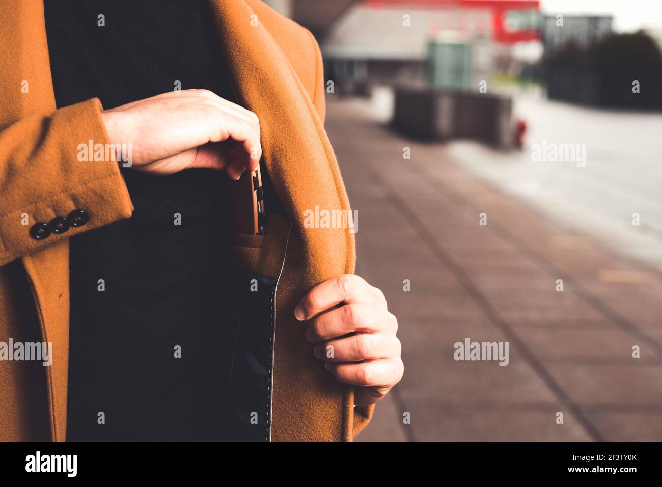 Man taking a wallet from the inside pocket of his coat Stock Photo - Alamy
