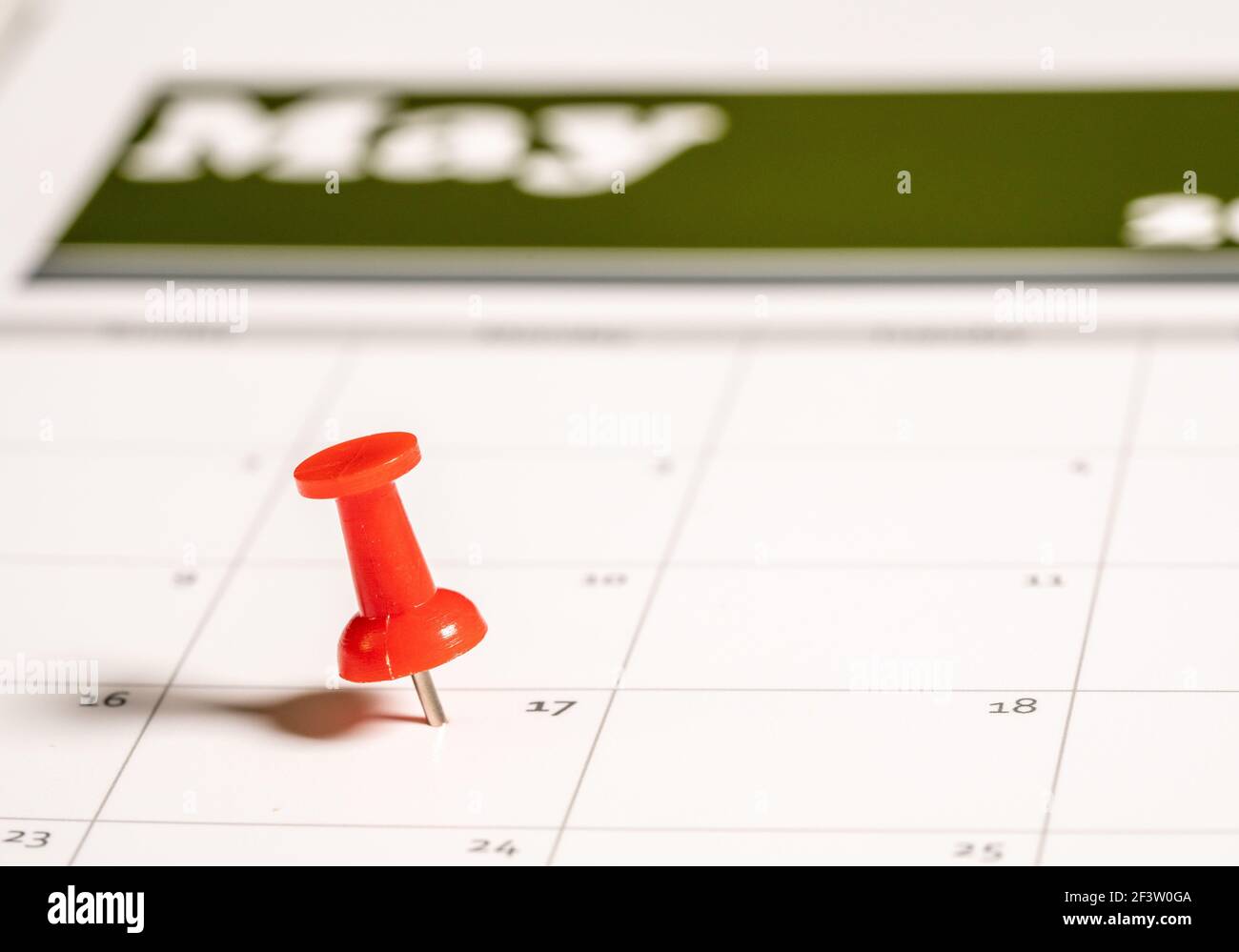 Calendar with pushpin inserted in the date for May 17 to illustrate the ...
