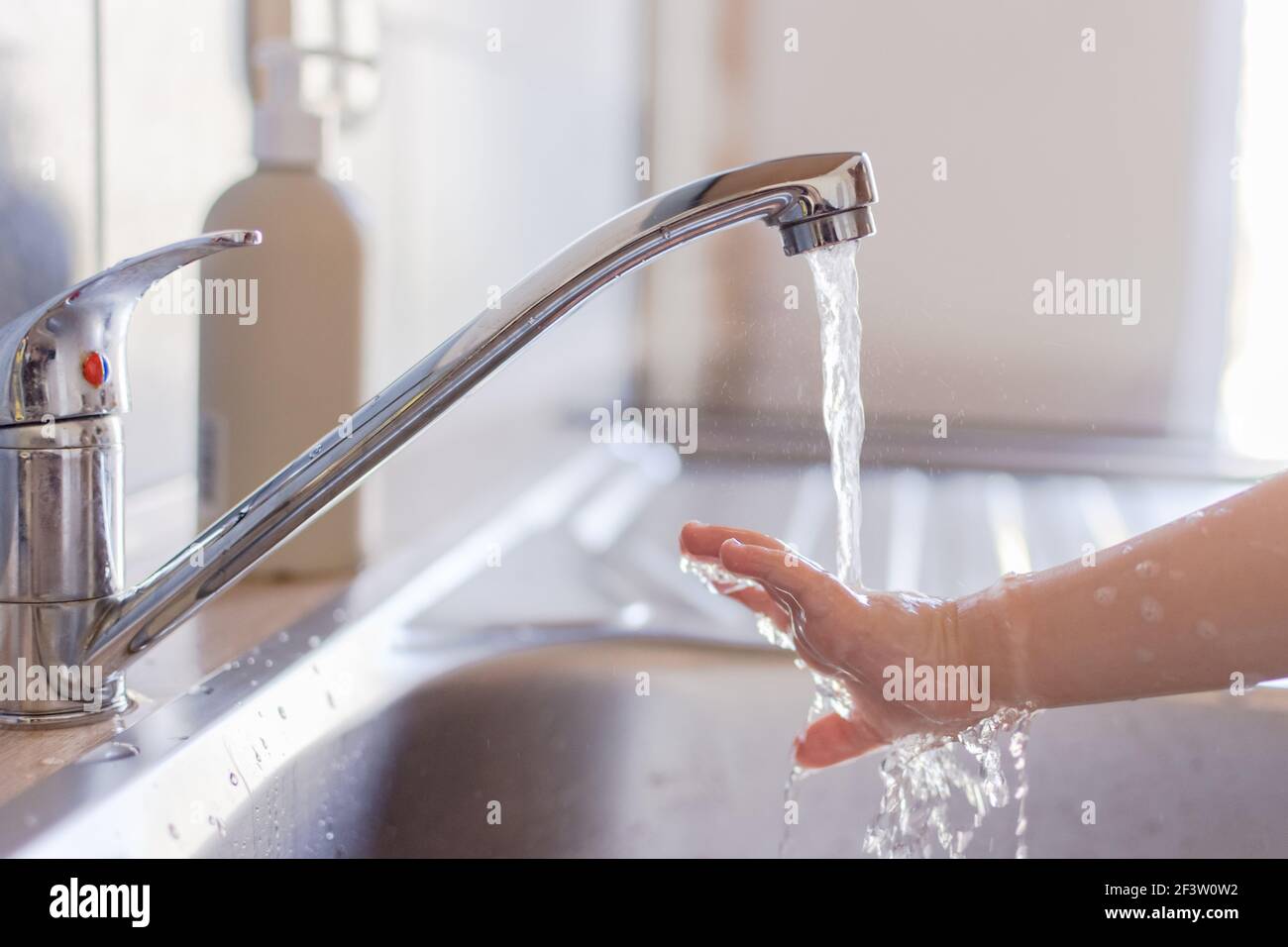 Close up hands of a small children washing hands with soap and water ...
