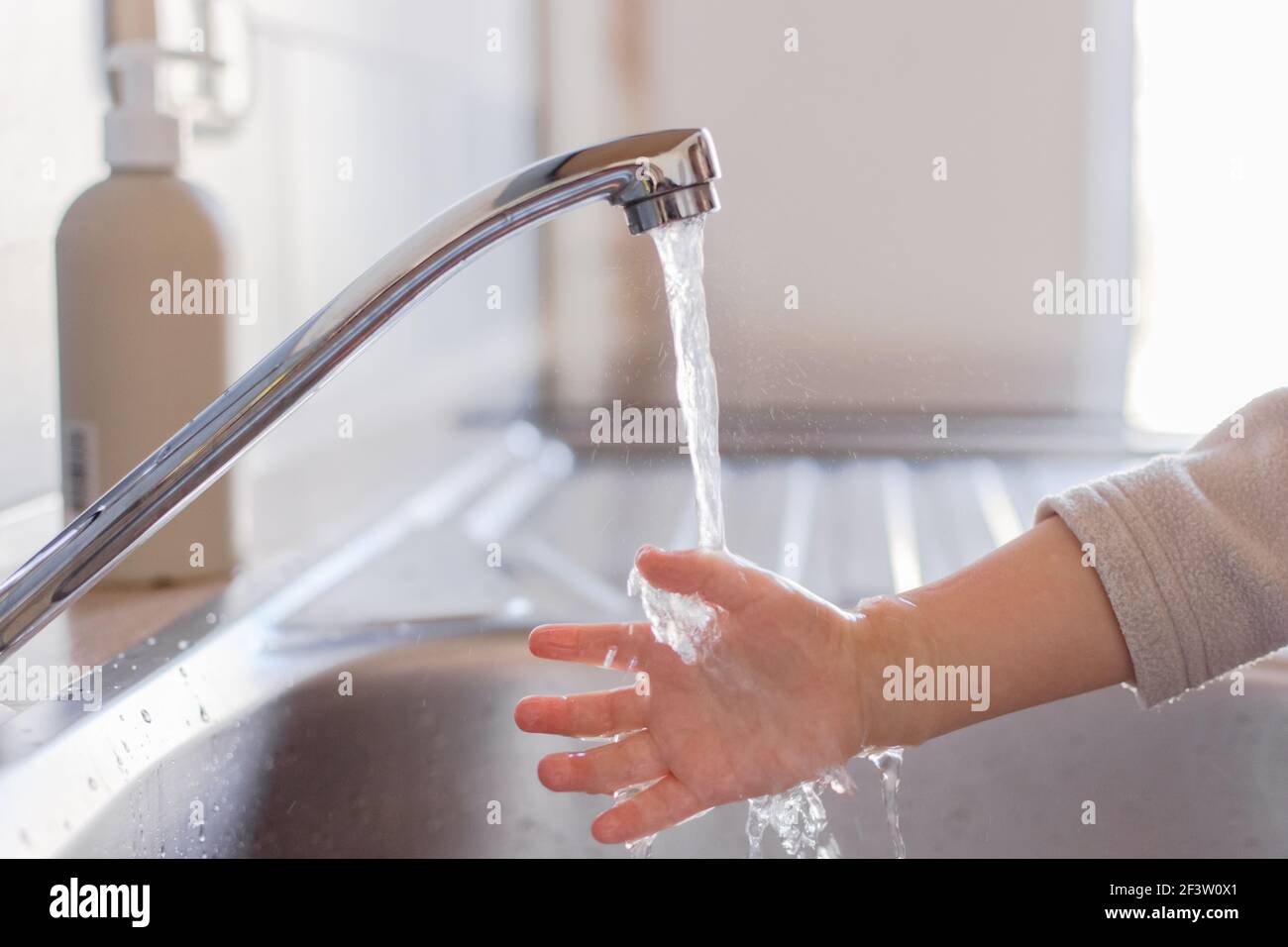 Close up hands of a small children washing hands with soap and water ...