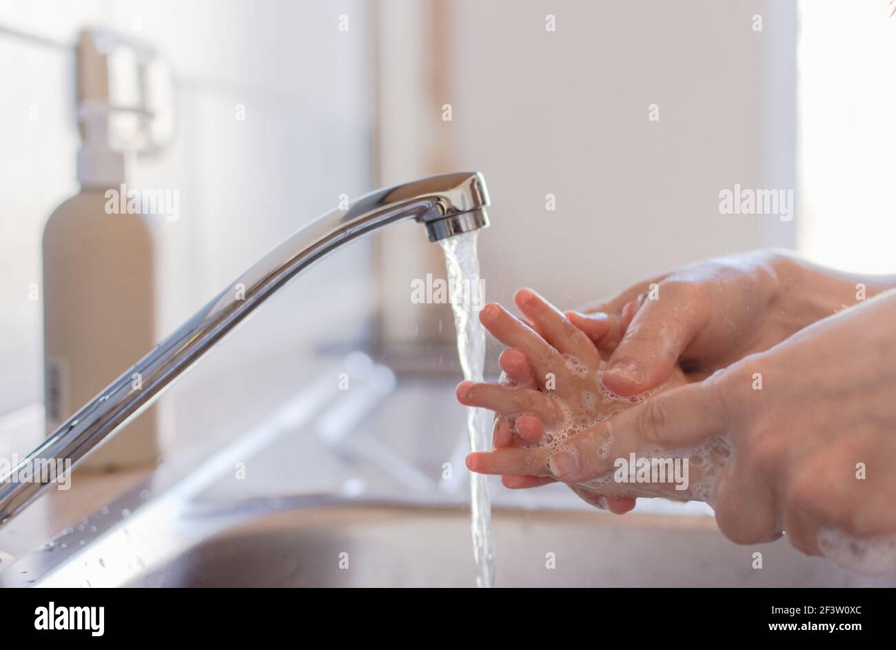 Close up hands of a small children washing hands with soap and water ...