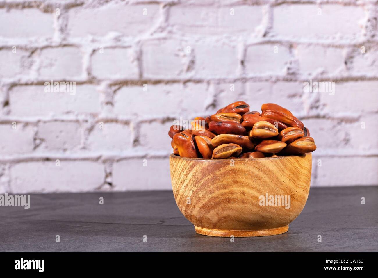 Dried fava beans in the wooden bowl - Vicia faba L Stock Photo - Alamy