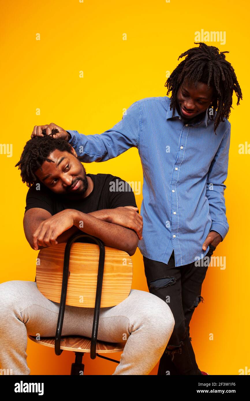 two african american guys posing cheerful together on yellow background ...