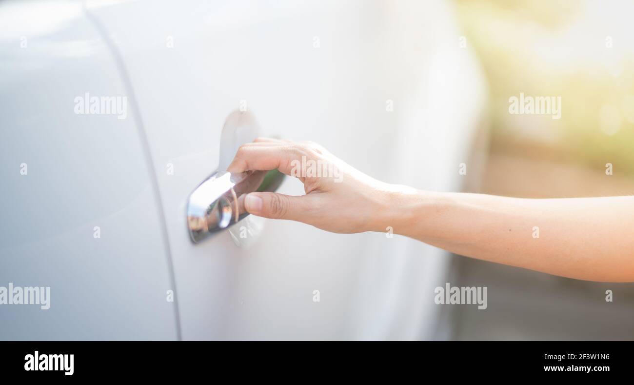 Female hand of a business woman with a pushing open botton of the car ...