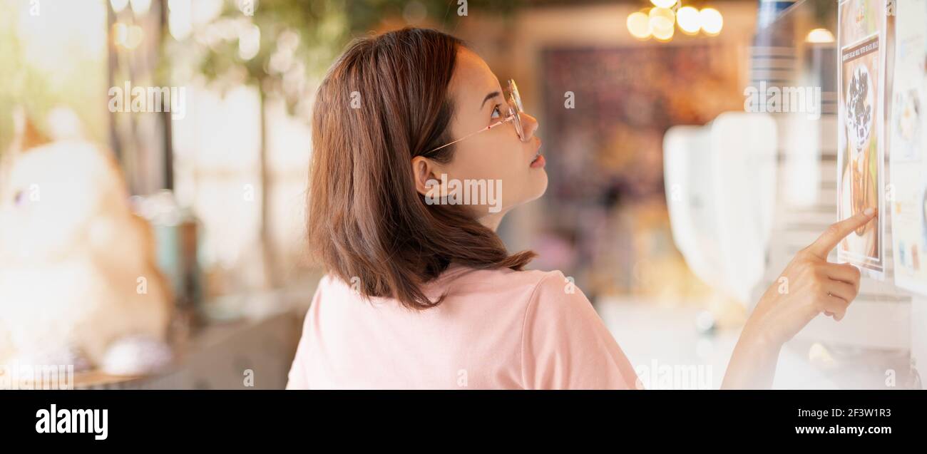 Female hand pointing at the menu for choosing eating at the coffee shop ...