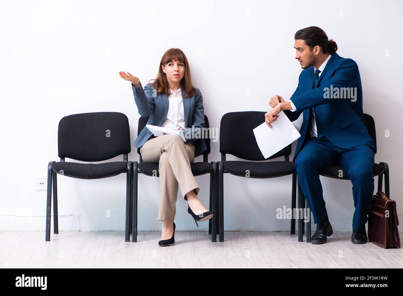 Businessman and businesswoman waiting for an interview at hall Stock ...