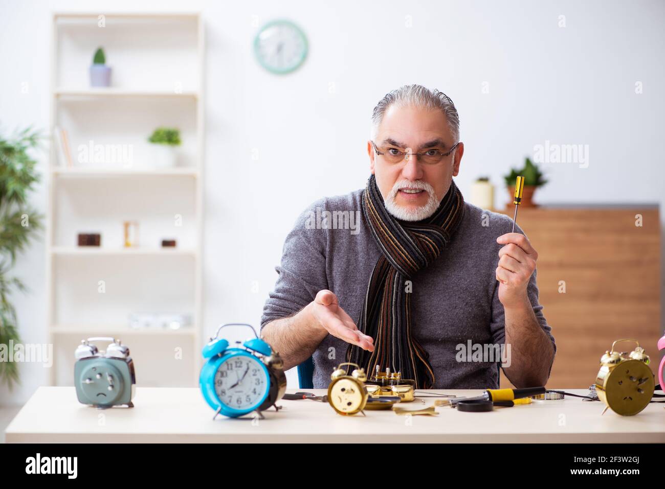 Old watchmaker working in the workshop Stock Photo - Alamy