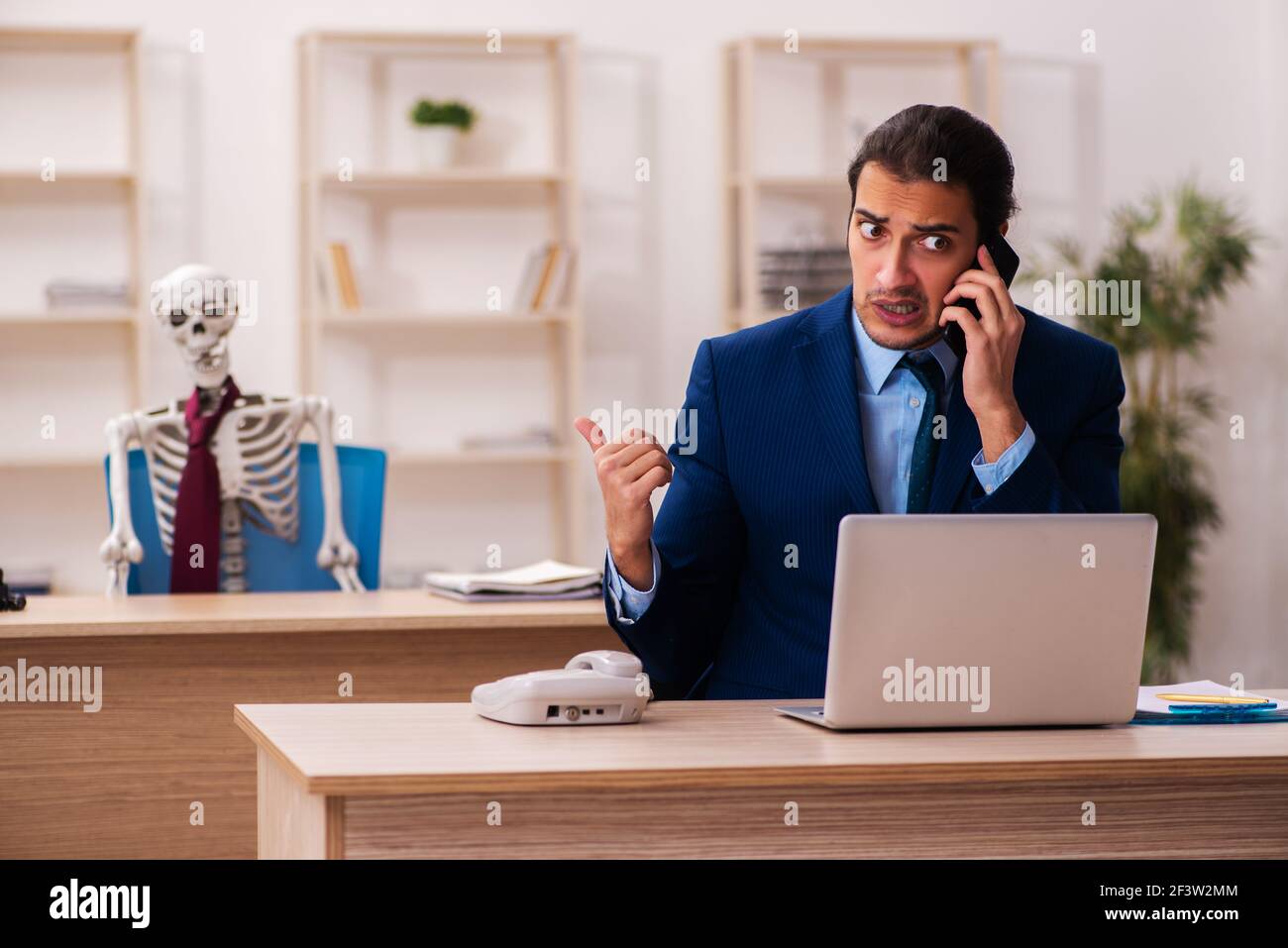 Dead employee working in the office in funny concept Stock Photo - Alamy