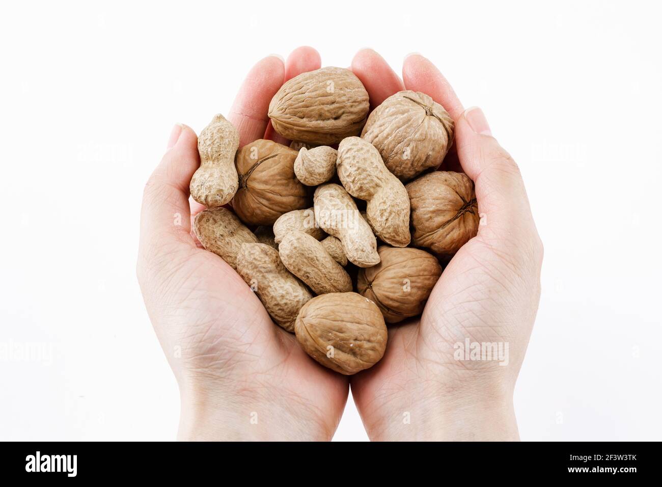 peanuts and walnuts on hands, white background Stock Photo - Alamy