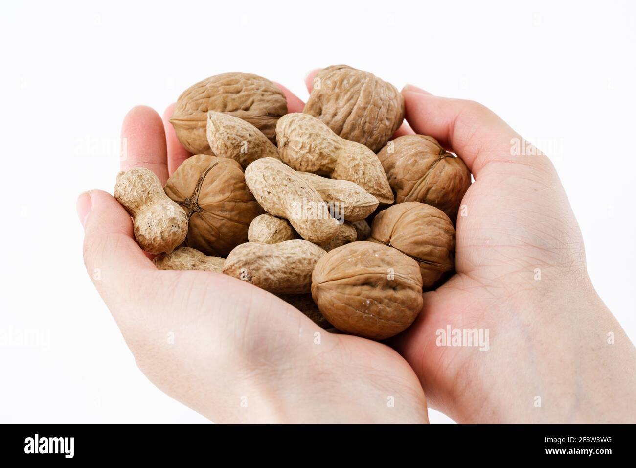 peanuts and walnuts on hands, white background Stock Photo - Alamy