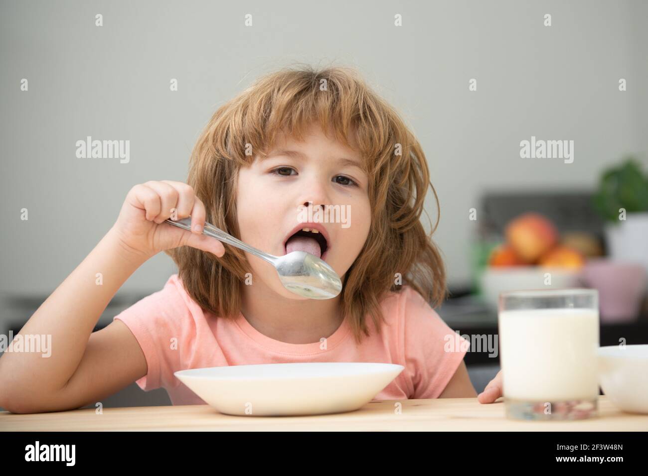 Portrait of cute child eating soup meal or breakfast having lunch by ...