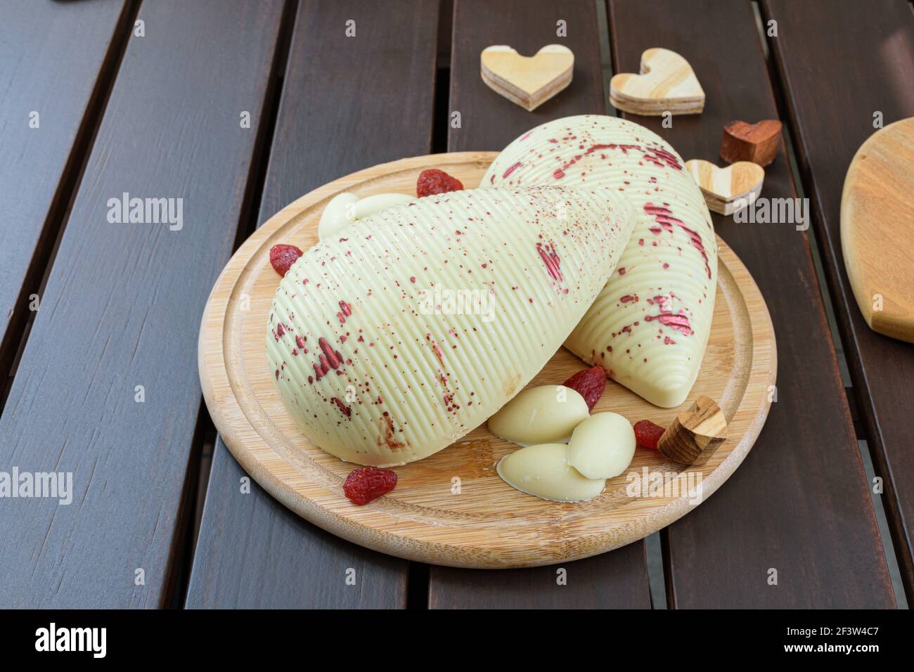 White chocolate Easter egg with candied strawberries, next to wooden ...