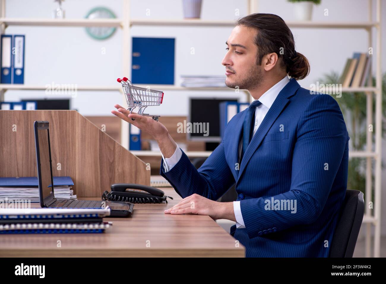 Young employee in e-commerce concept Stock Photo - Alamy