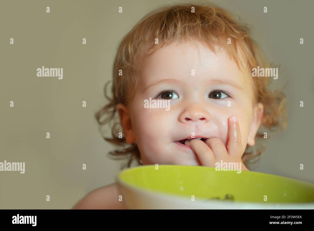 Smiling baby eating food. Healthy nutrition for kids. Funny child face ...