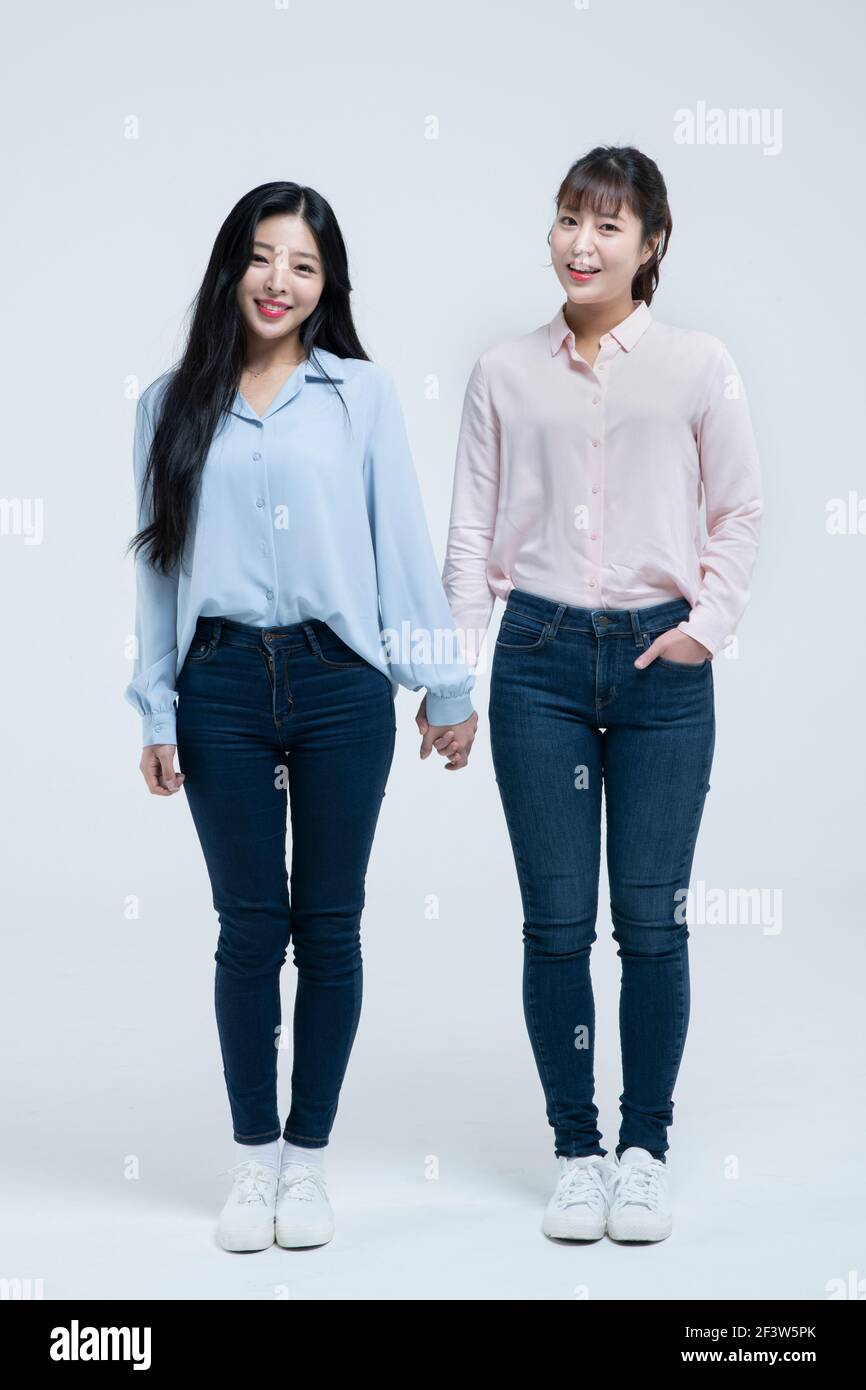 two Asian women standing and holding hands, white background Stock ... two Asian women standing and holding hands, white background Stock ...