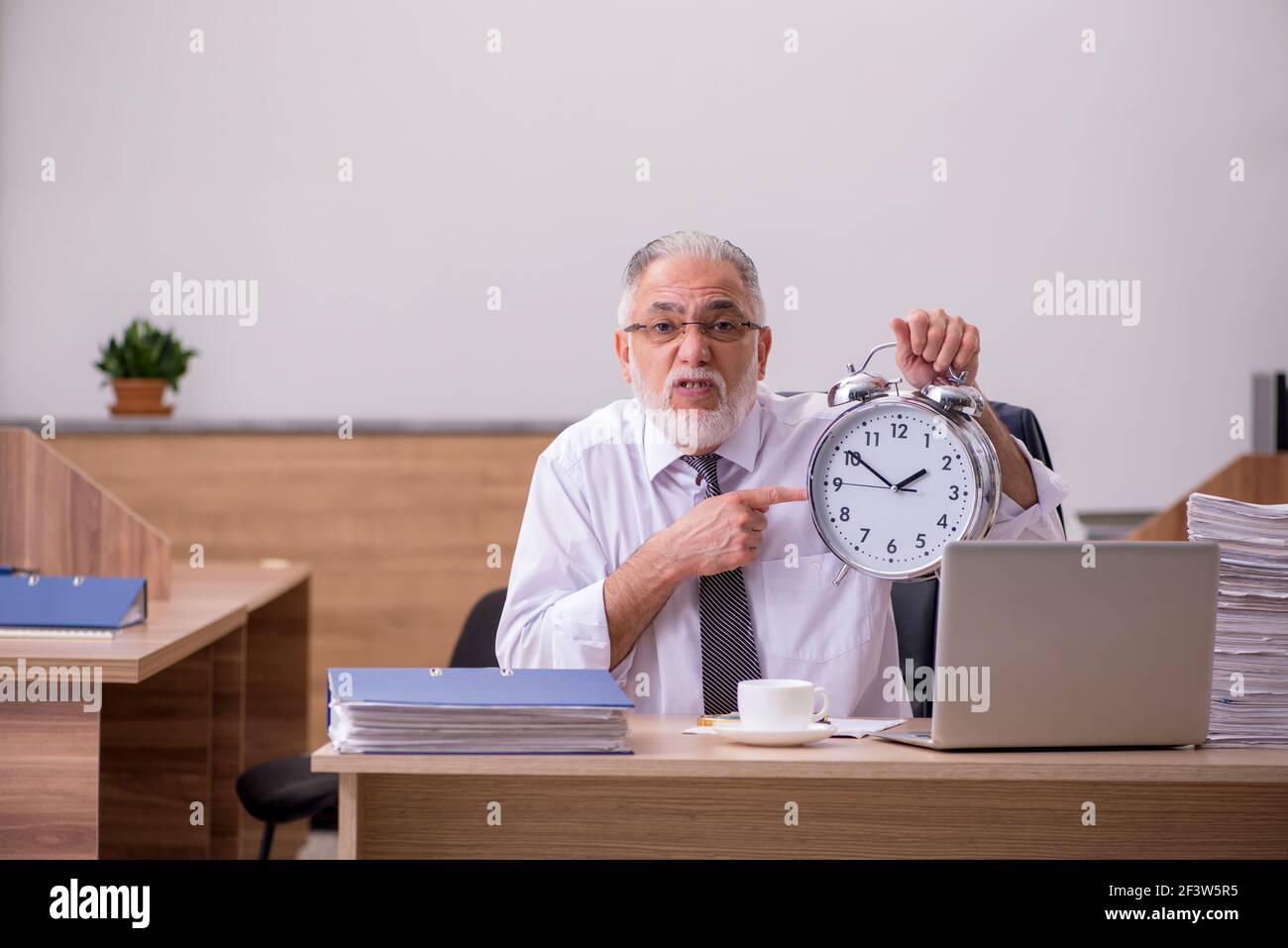 Old employee in time manegement concept Stock Photo - Alamy
