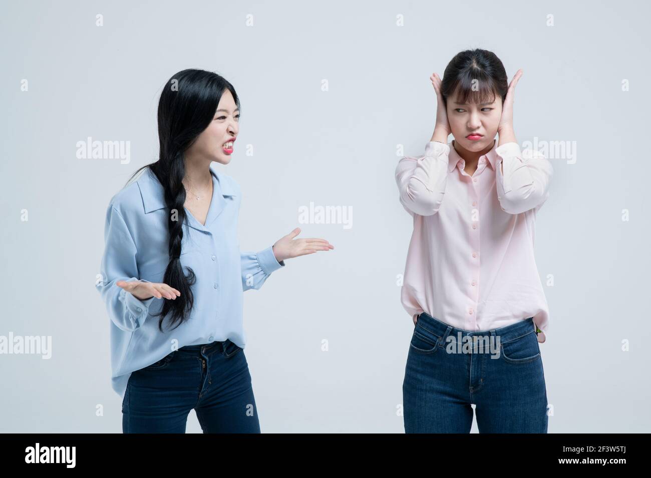 Asian sisters, women fighting concept, white background Stock Photo - Alamy