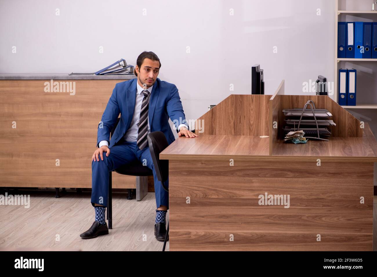 Young employee sitting at workplace Stock Photo - Alamy