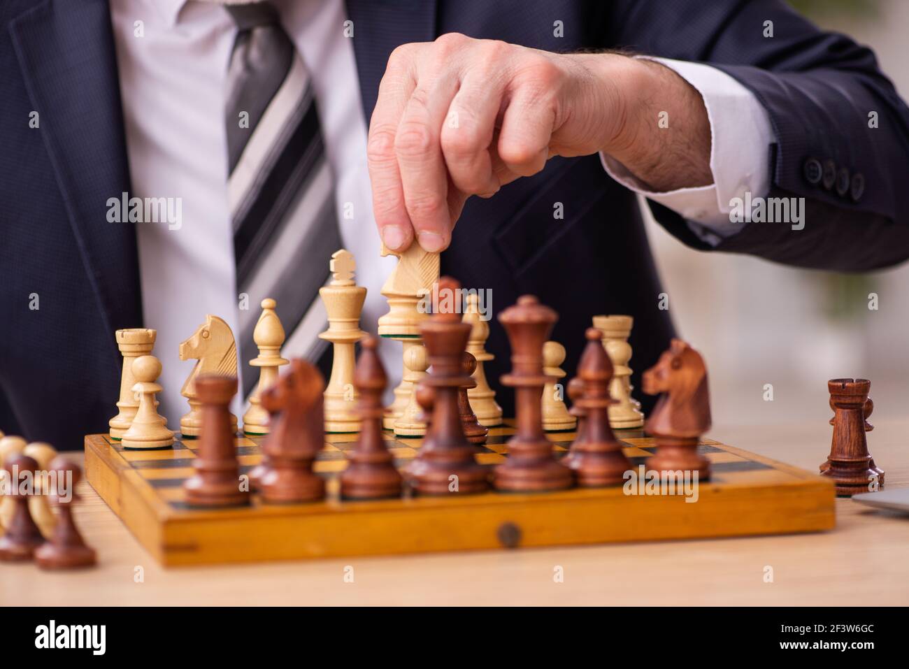 Old businessman employee playing chess at workplace Stock Photo - Alamy