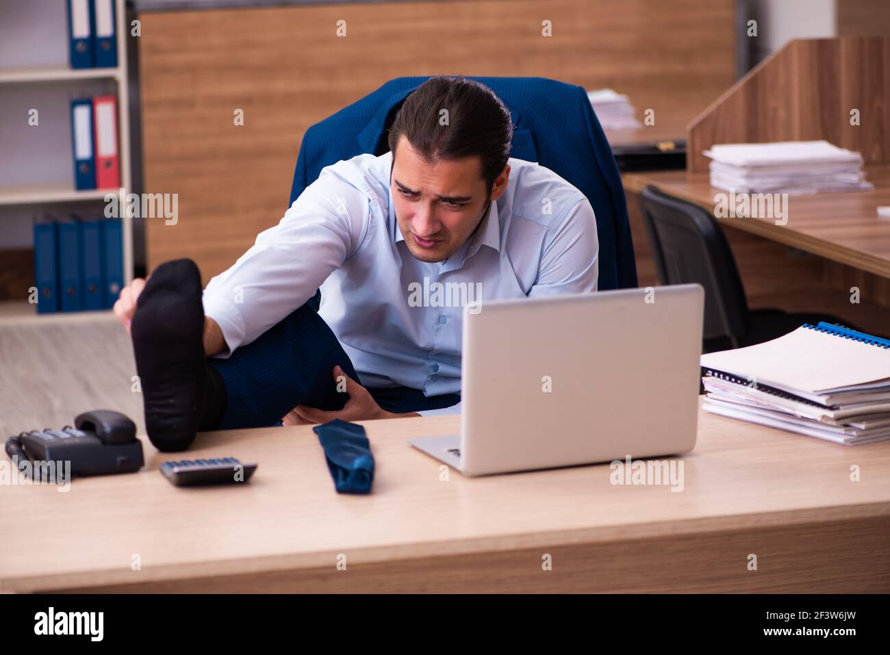 Young employee doing physical exercises at workplace Stock Photo - Alamy