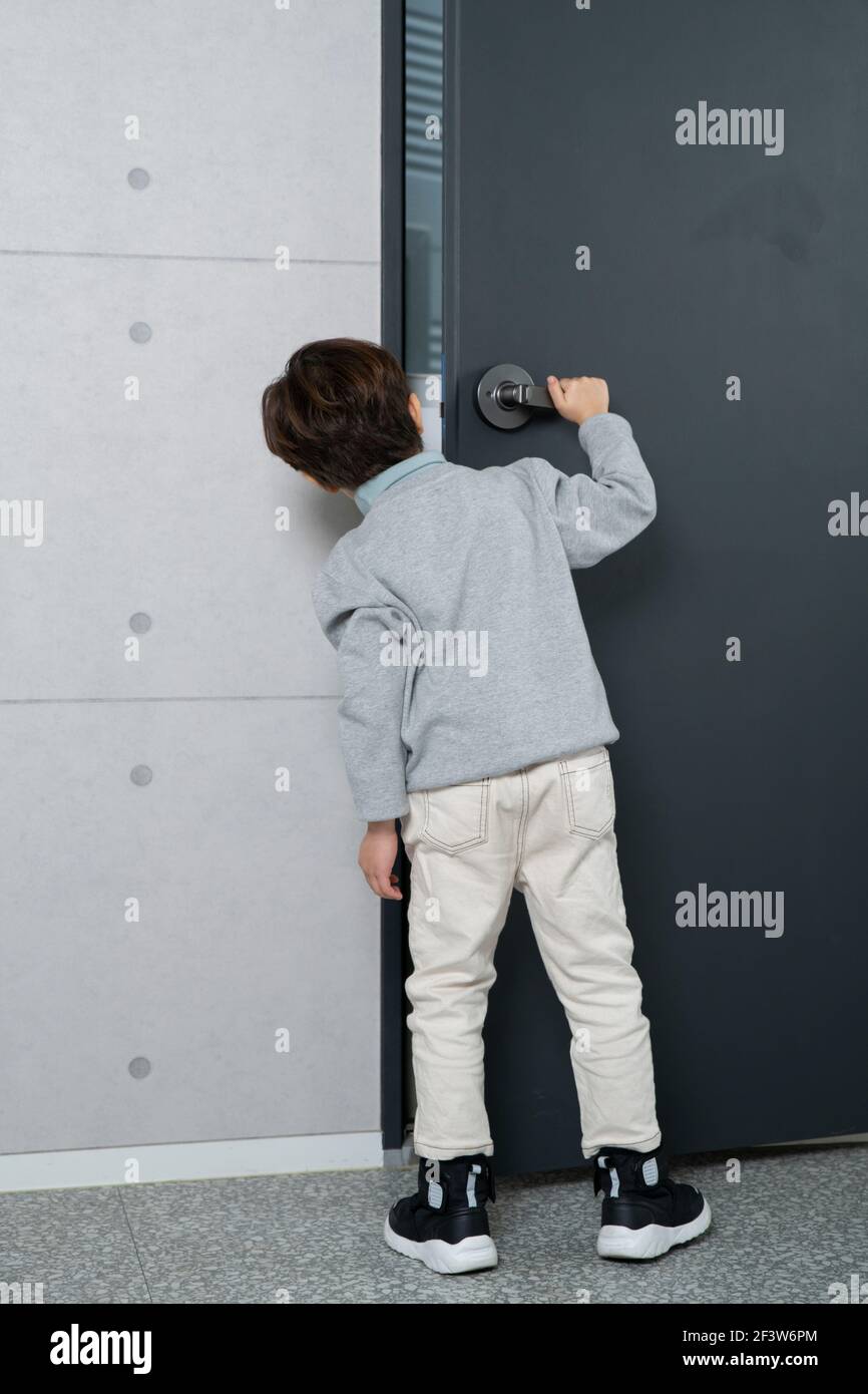 Asian boy opening door Stock Photo - Alamy