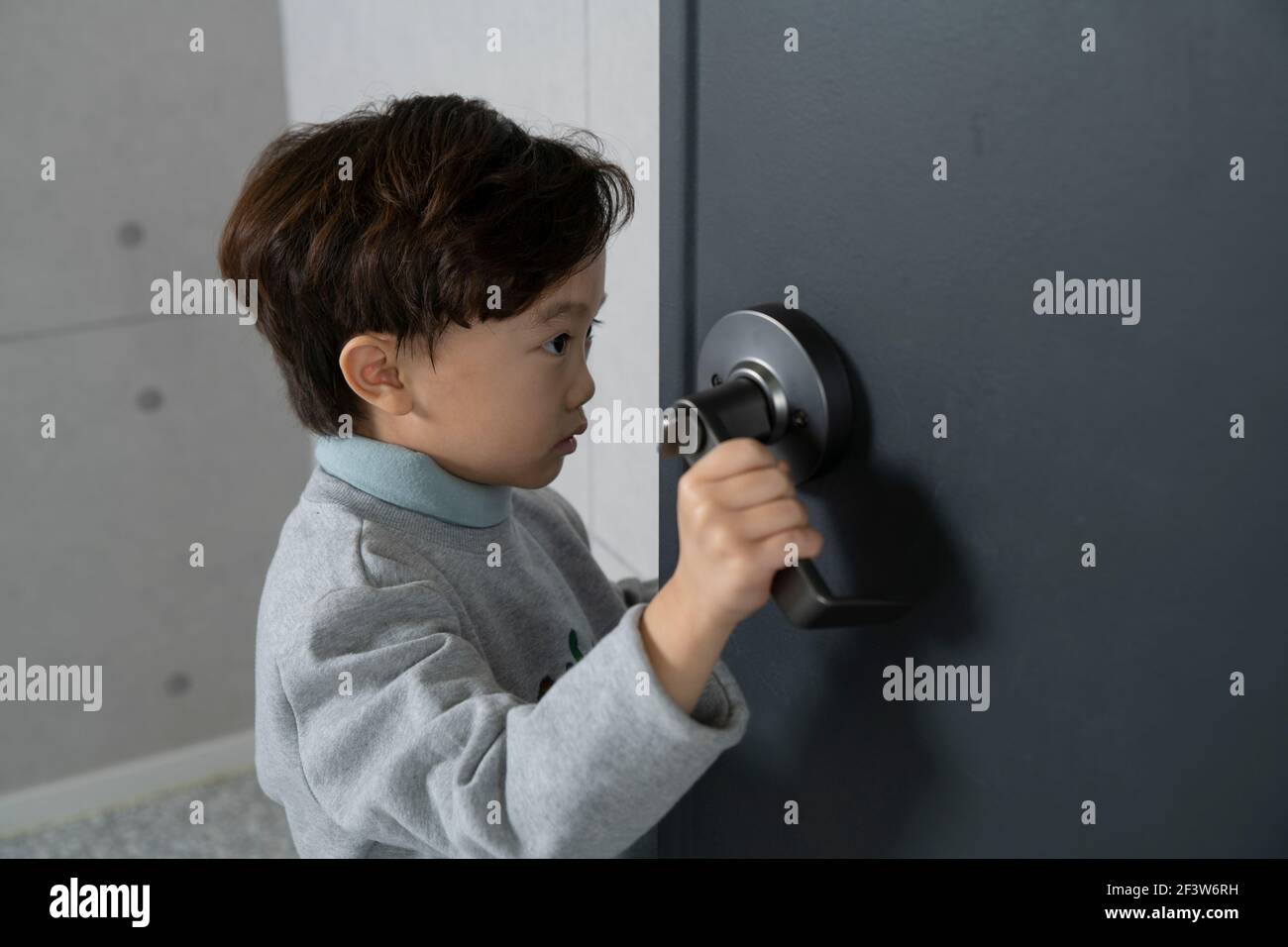 Asian boy opening door Stock Photo - Alamy