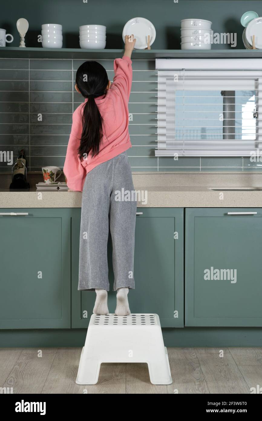 Asian child trying to cook alone in the kitchen Stock Photo - Alamy