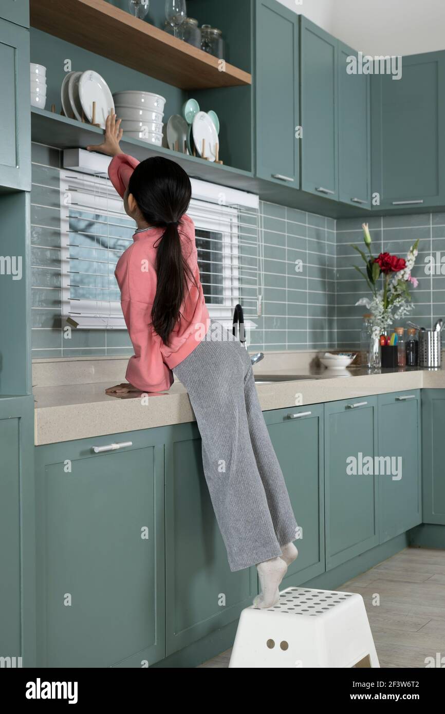 Asian child trying to cook alone in the kitchen Stock Photo - Alamy