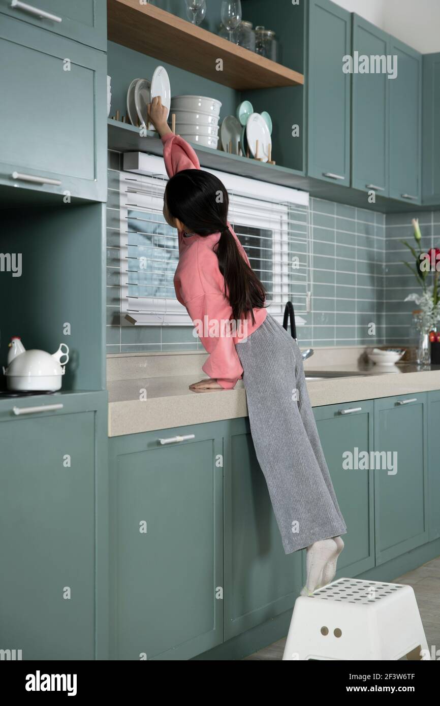 Asian child trying to cook alone in the kitchen Stock Photo - Alamy