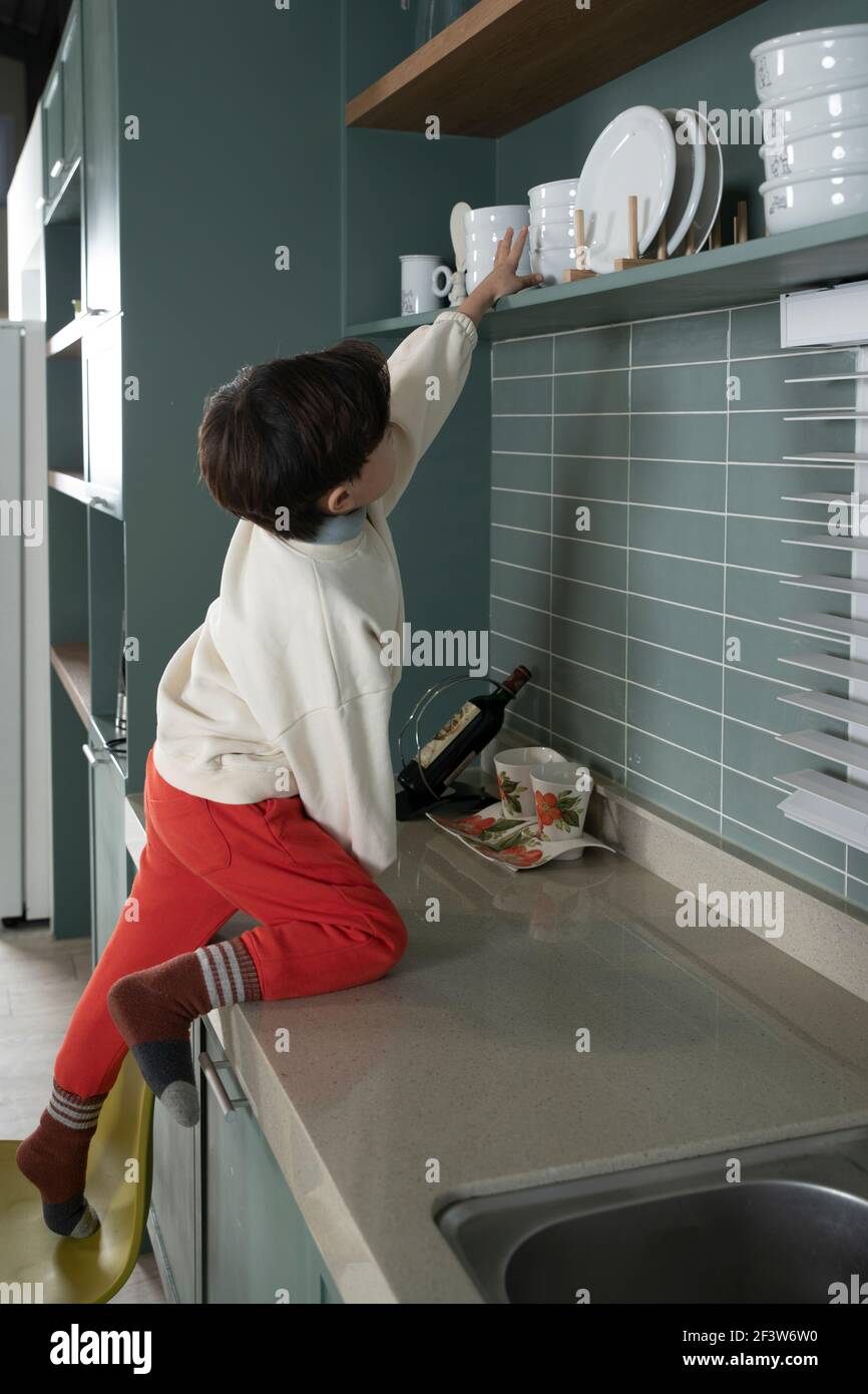Asian child trying to cook alone in the kitchen Stock Photo - Alamy