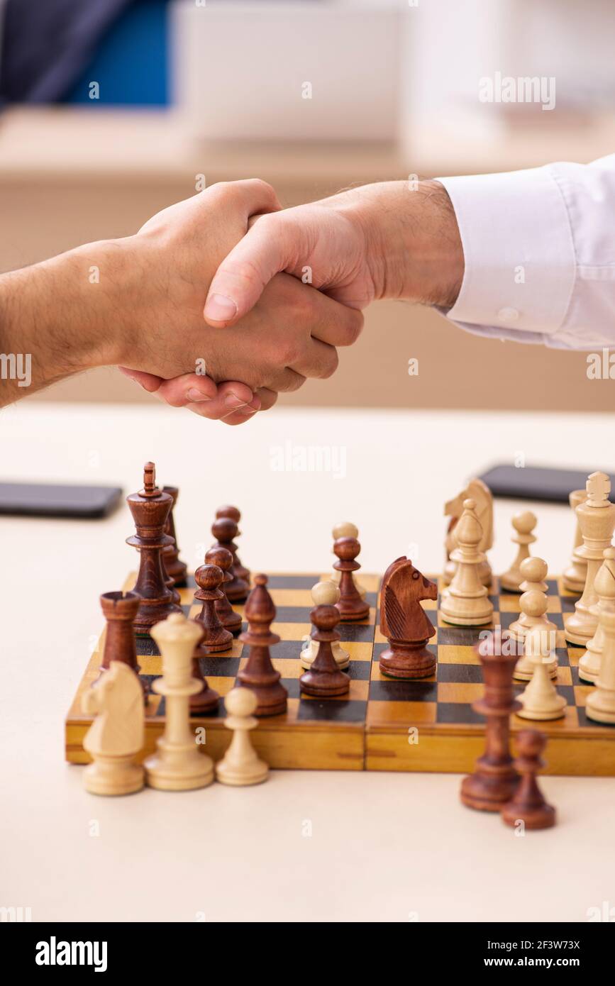 Two male employees playing chess at workplace Stock Photo - Alamy
