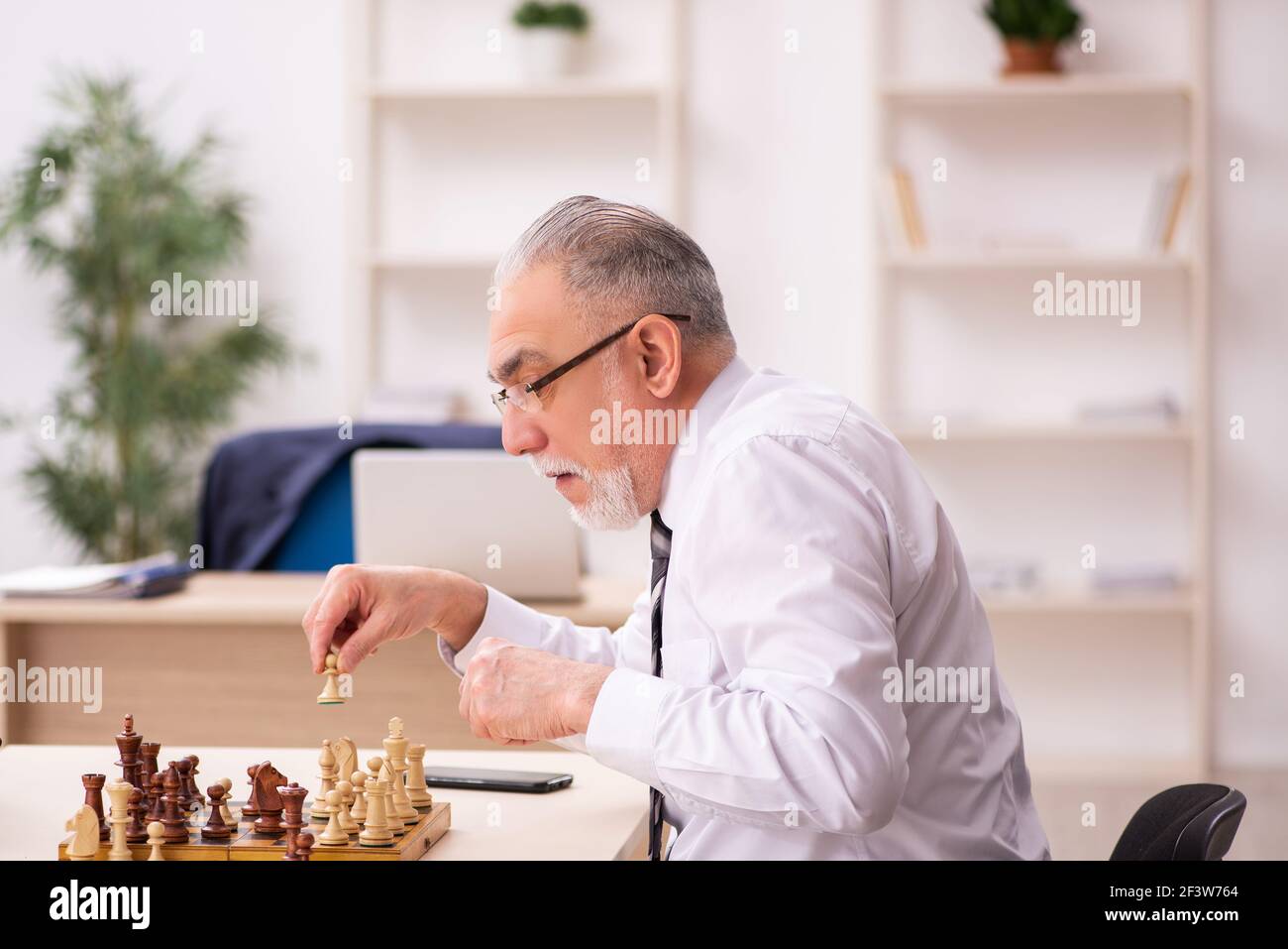 Two male employees playing chess at workplace Stock Photo - Alamy