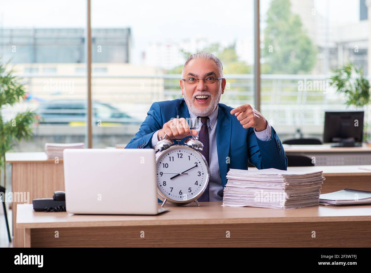 Old boss employee in time management concept Stock Photo - Alamy