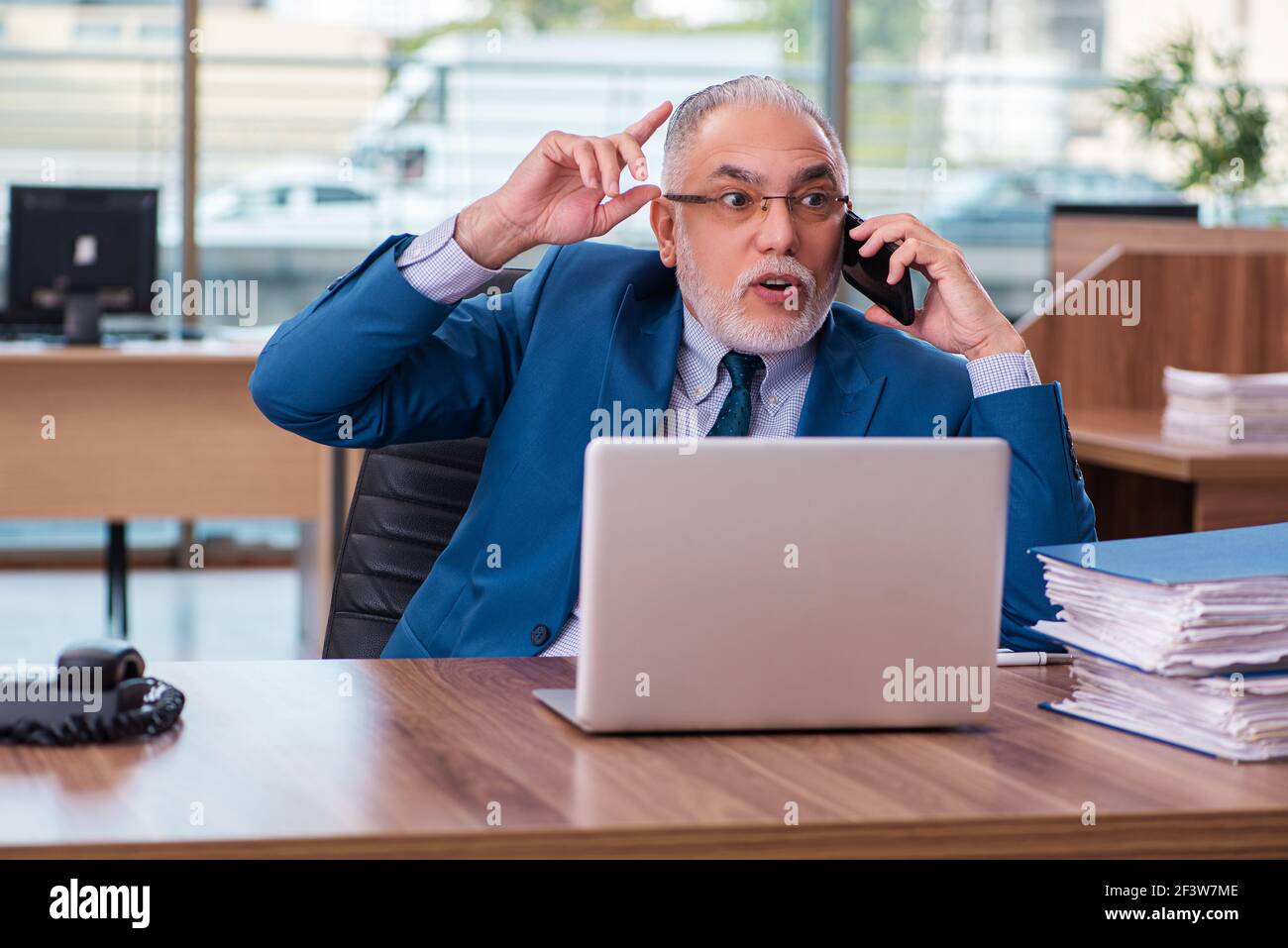 Old employee working in the office Stock Photo - Alamy