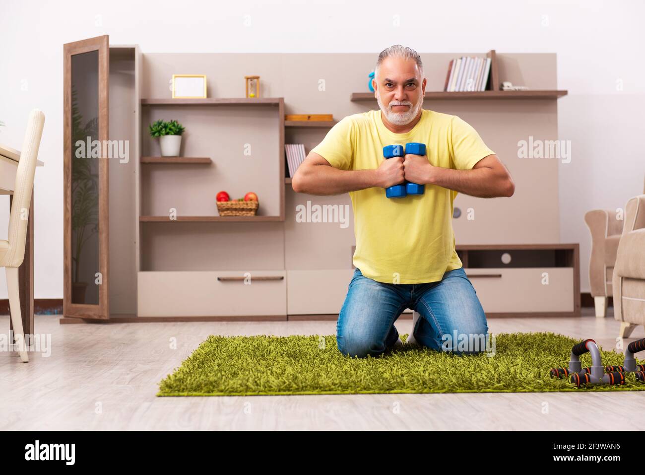 Old man doing sport exercises at home Stock Photo - Alamy