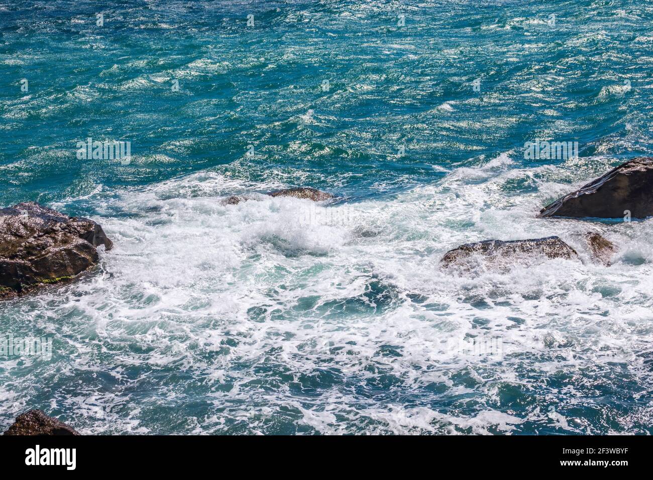 Sea water beats against rocks. Sea waves of dark water beat against the ...