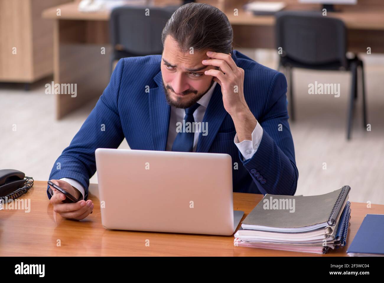 Young male employee working at workplace Stock Photo - Alamy