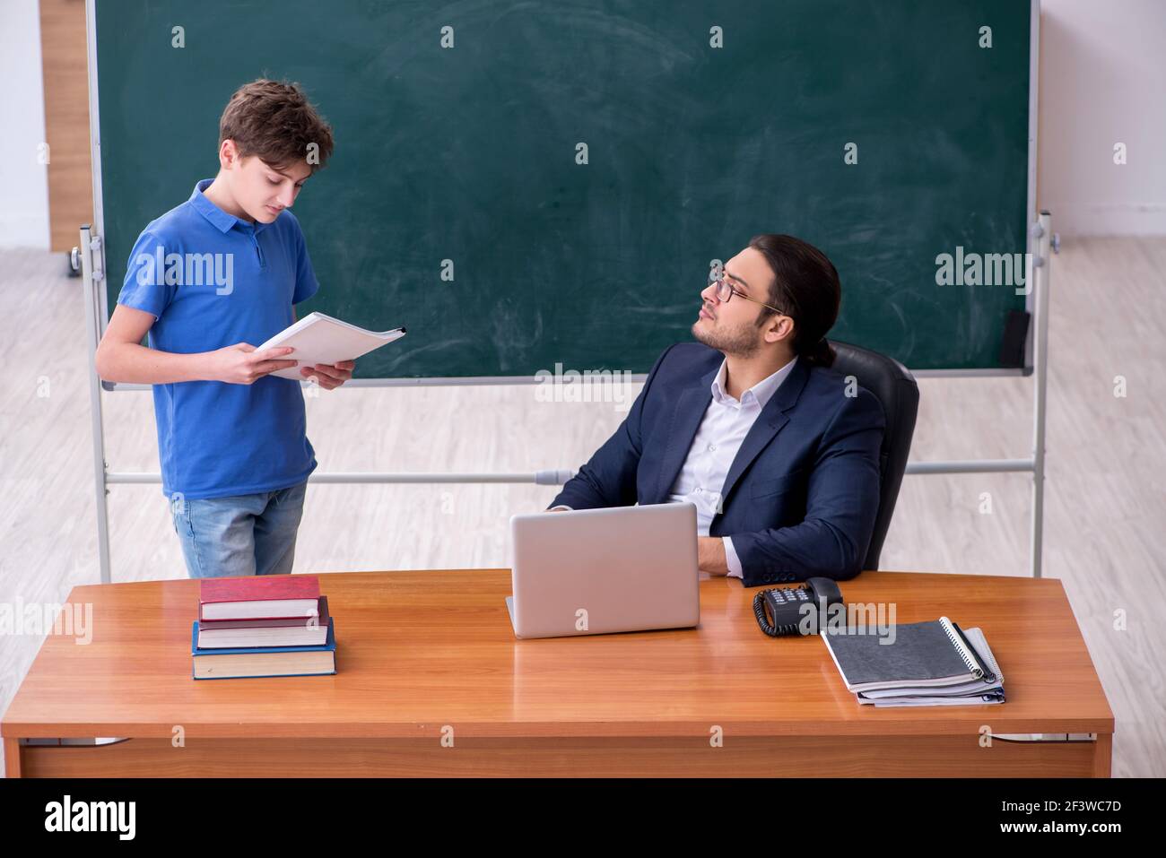 Male teacher and schoolboy in the classroom Stock Photo - Alamy