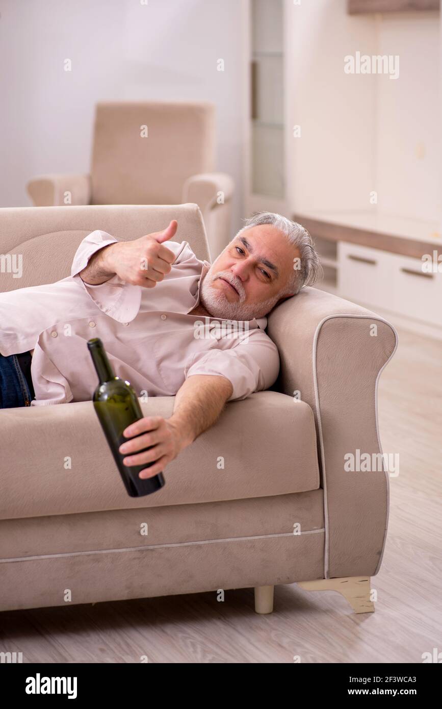 Aged man drinking alcohol at home Stock Photo - Alamy